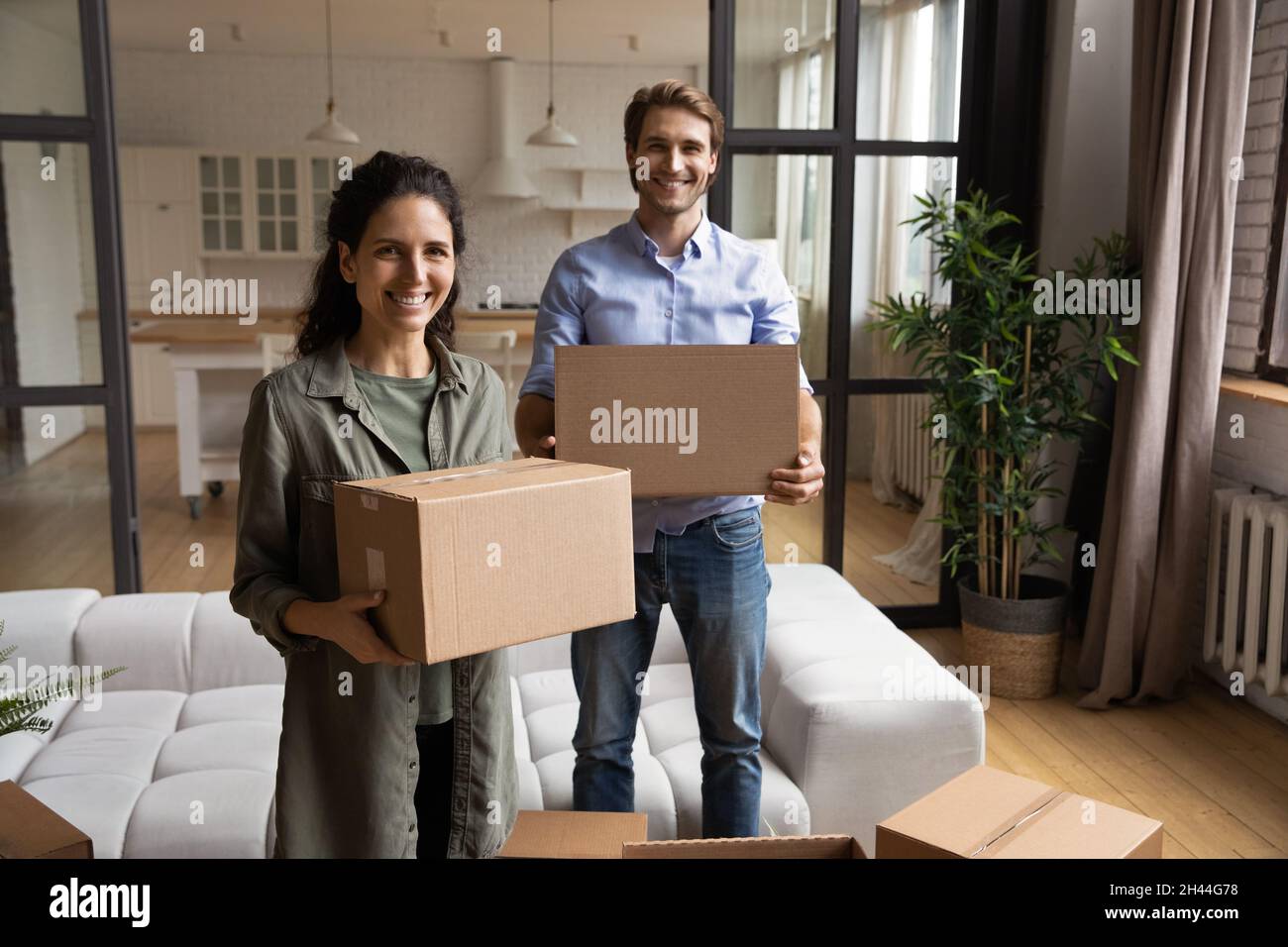 Couple pose in living room with cardboard boxes in hands Stock Photo ...