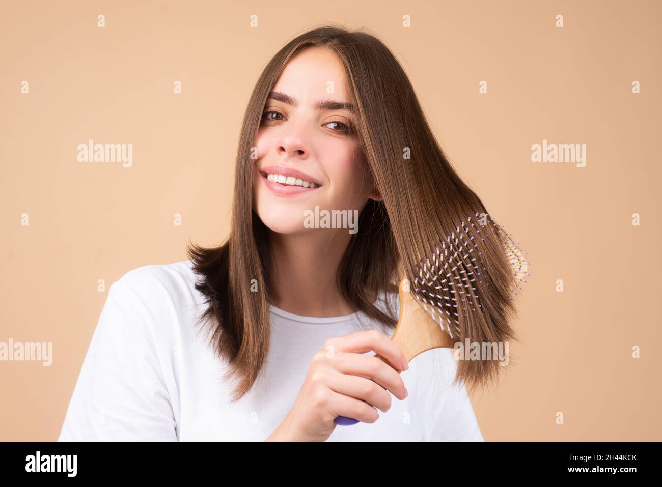 Beautiful woman combs her healthy hair. Combing healthy long straight ...