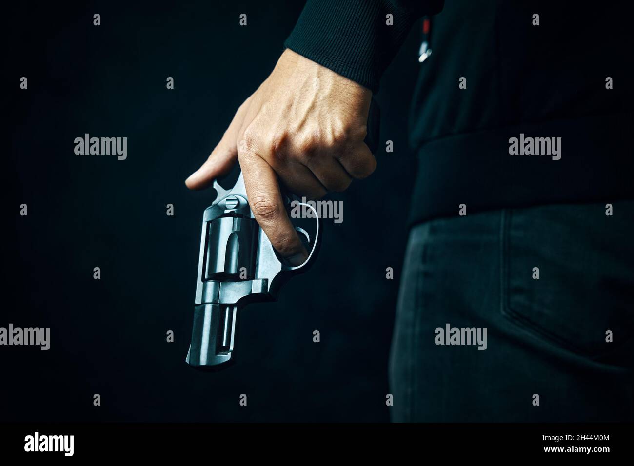 Black revolver with drum in man's hand. Guy with gun down. Firearms for ...