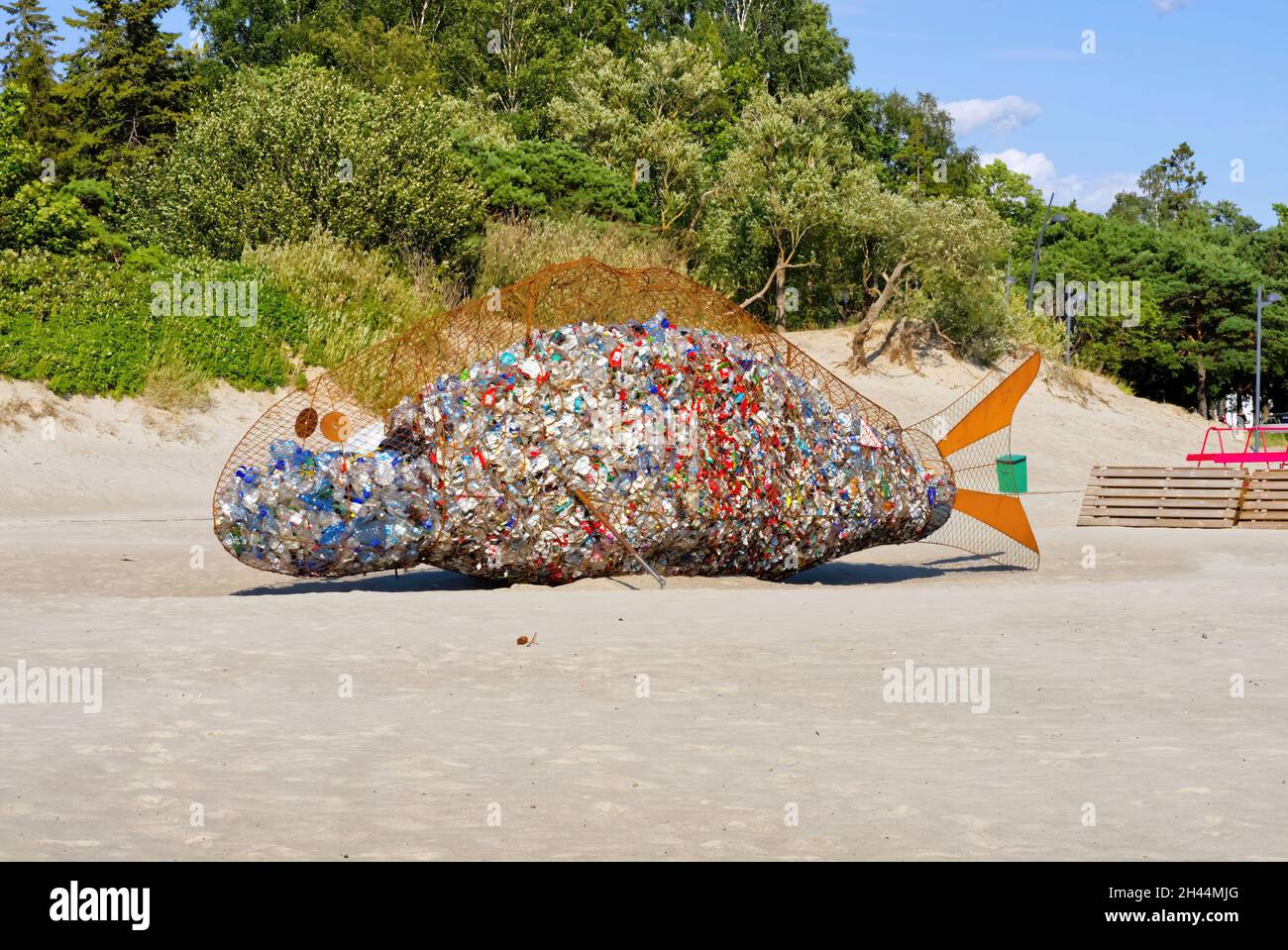 dumpster in the form of a huge fish with garbage inside Stock Photo - Alamy