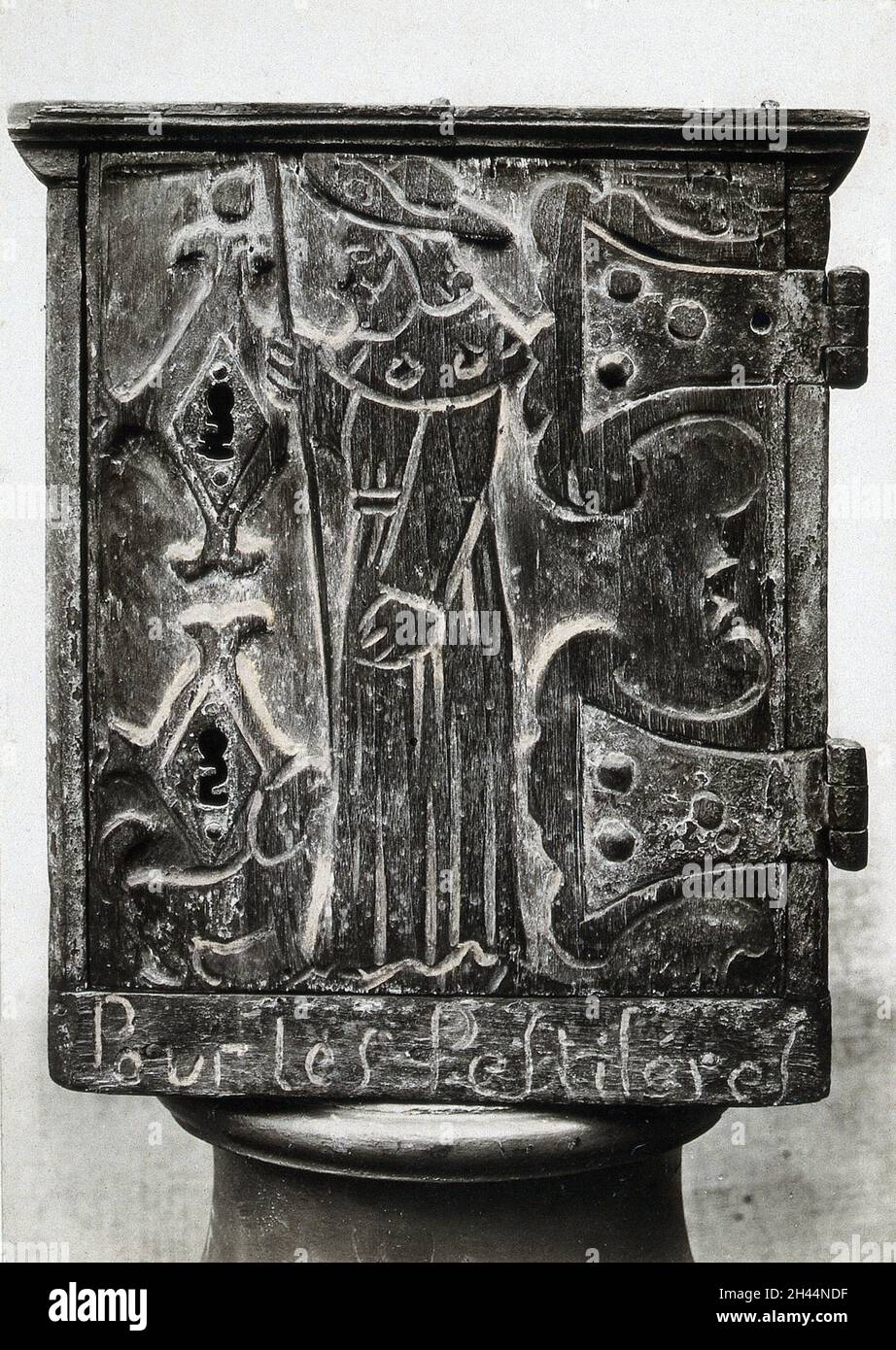 A wooden plague box, carved in low relief with the figure of Saint Roch ...