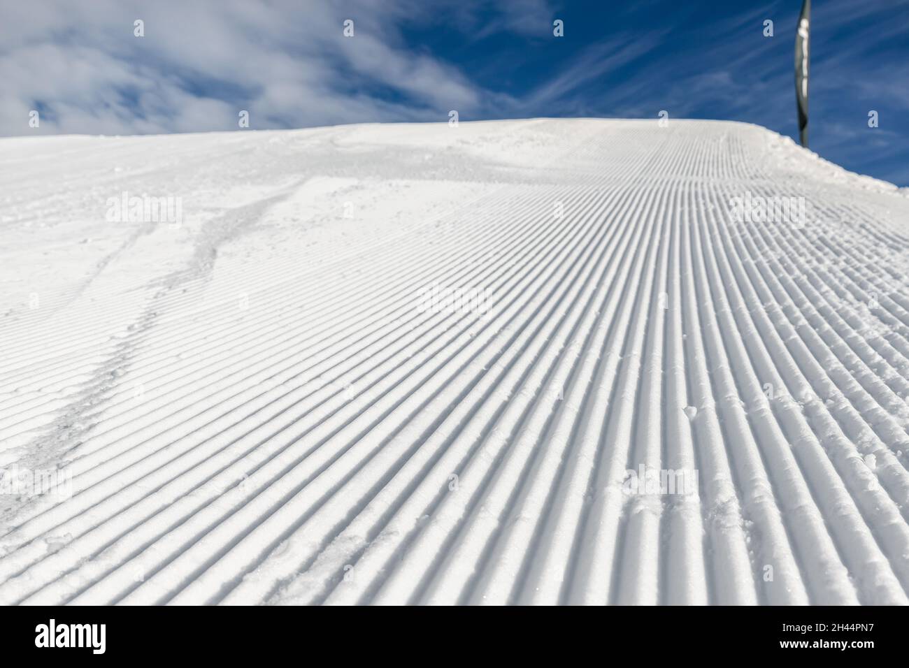 Close-up straight line rows of freshly prepared groomed ski slope piste ...