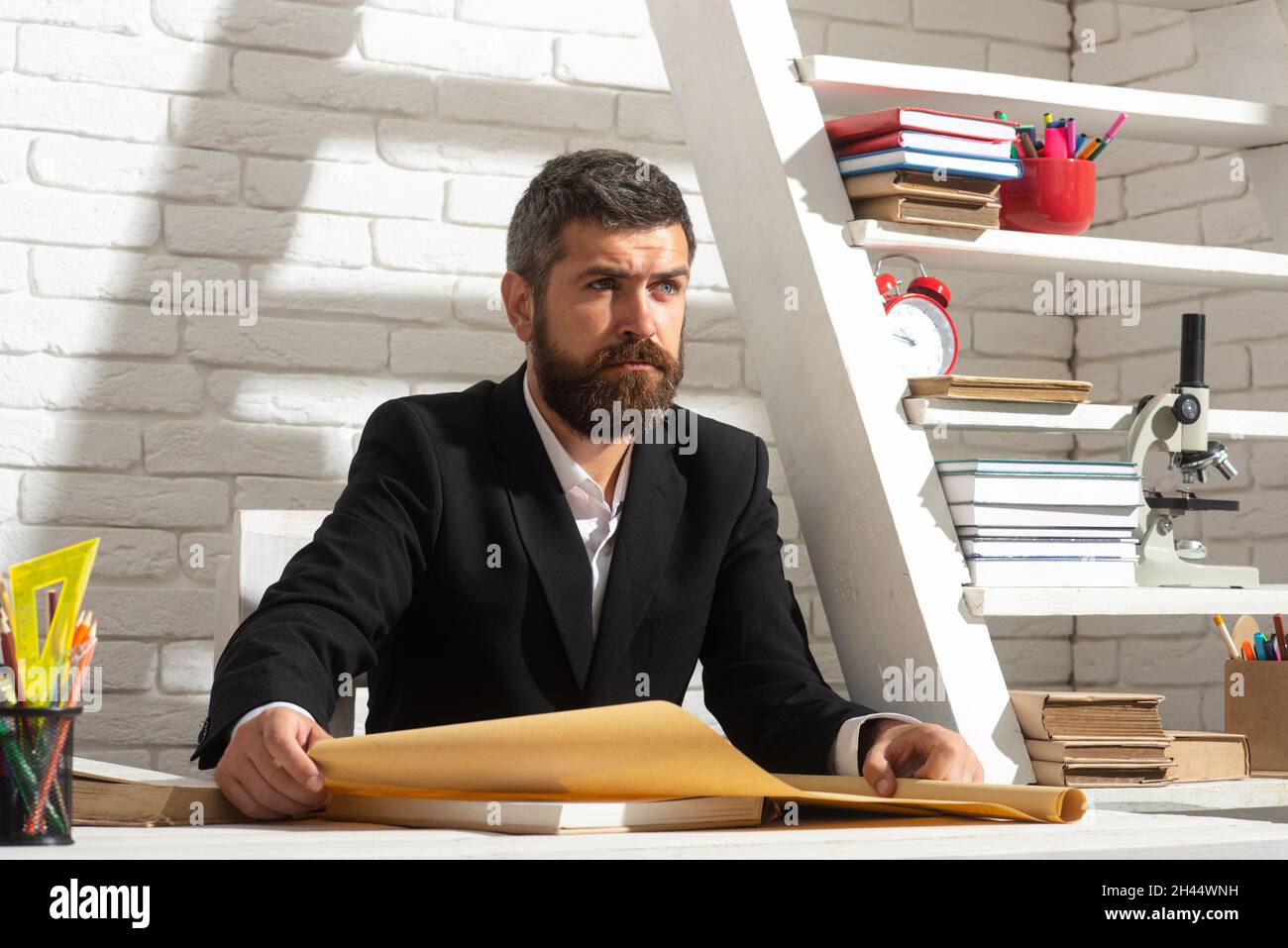 Teacher working at desk. Portrait of thinking male teacher, professor ...