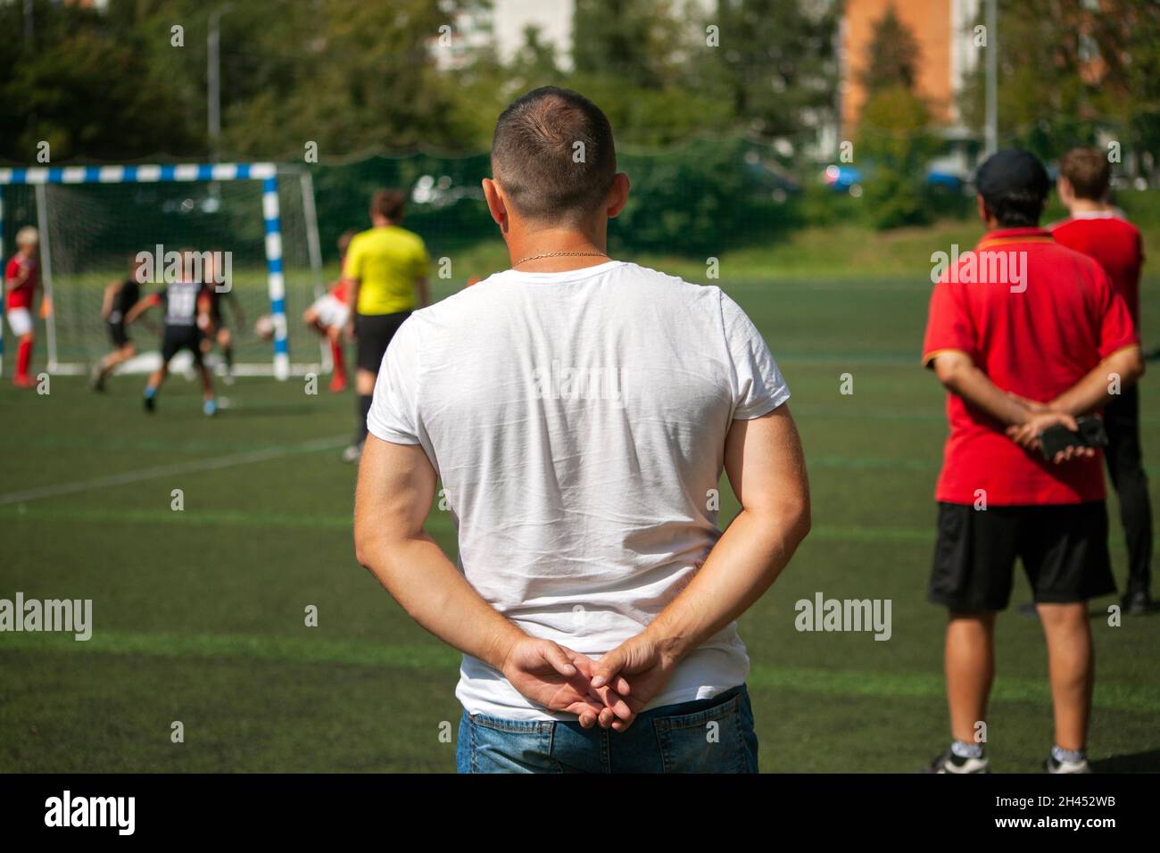 The coach watches football. The father looks at the son of a football ...