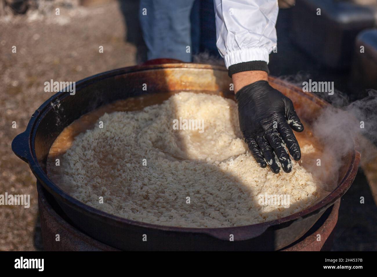 Cooking rice. Cook cooks pilaf on the street. A shot of food in natural ...