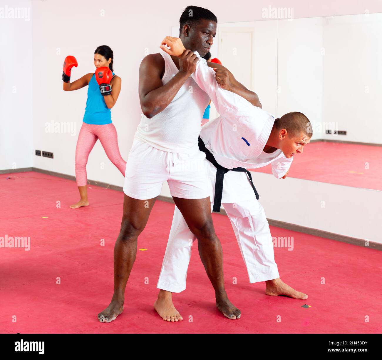 Self defense training in gym. Men in sparring train to do power grabs ...