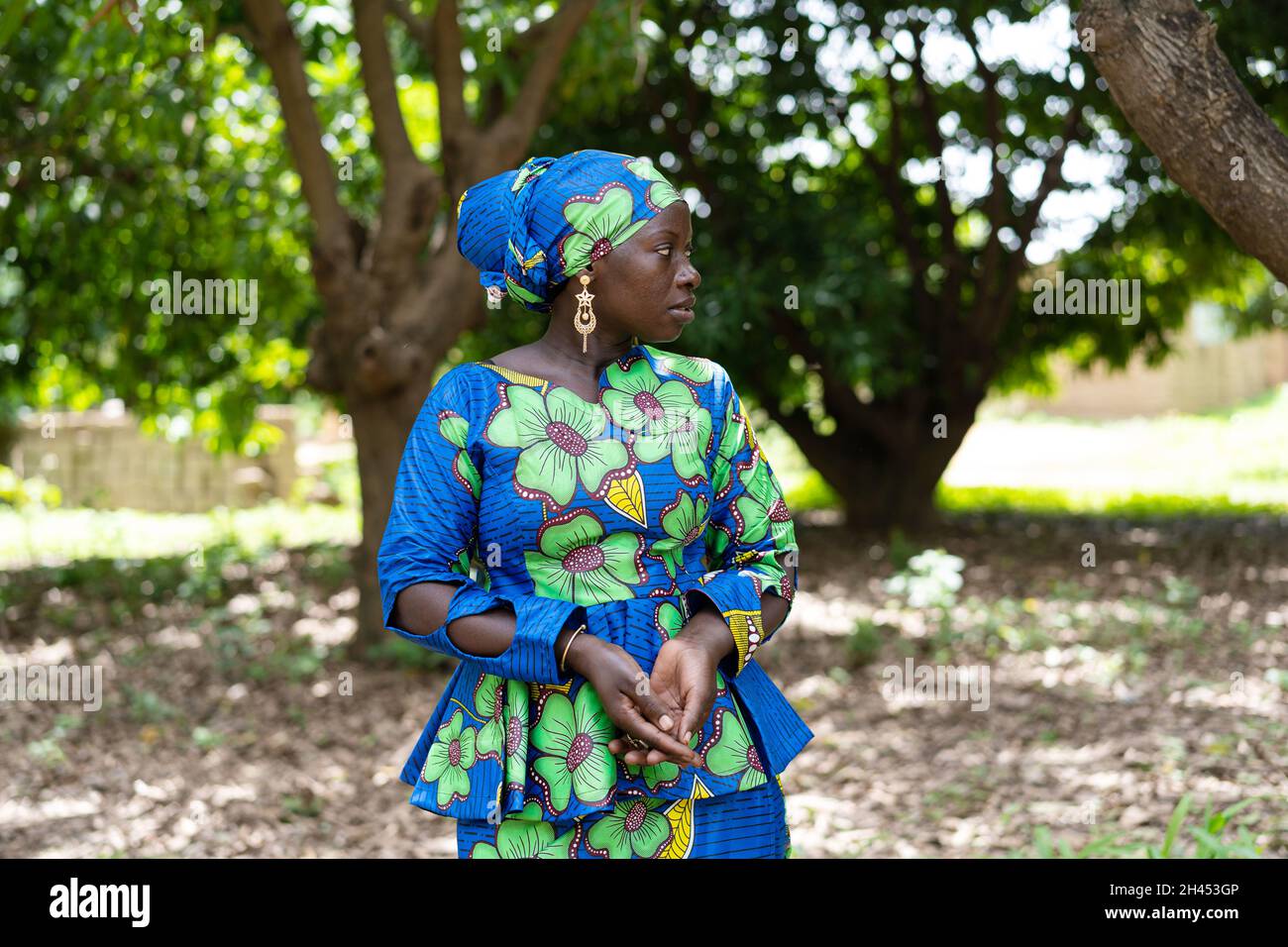 Pretty black African lady in an elegant dress, standing in front of a ...
