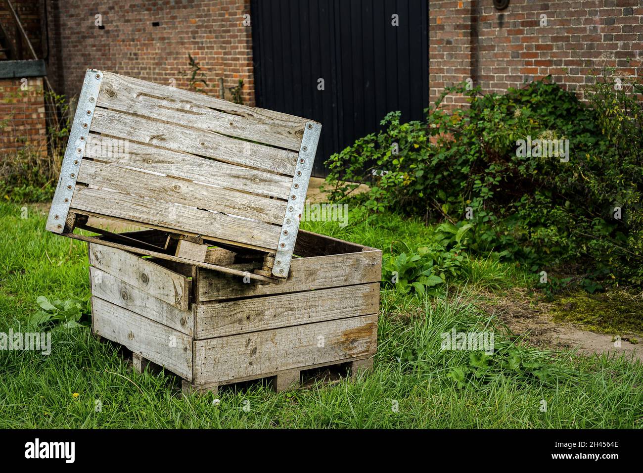 Wooden fruit crates stacked on top of one another on grass outside farm ...