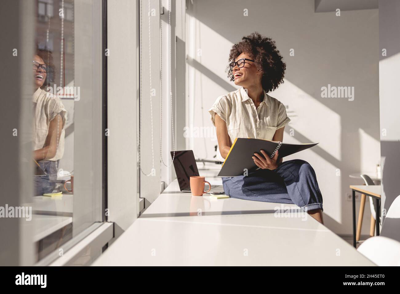Pretty female manager sitting at work desk in coworking Stock Photo - Alamy