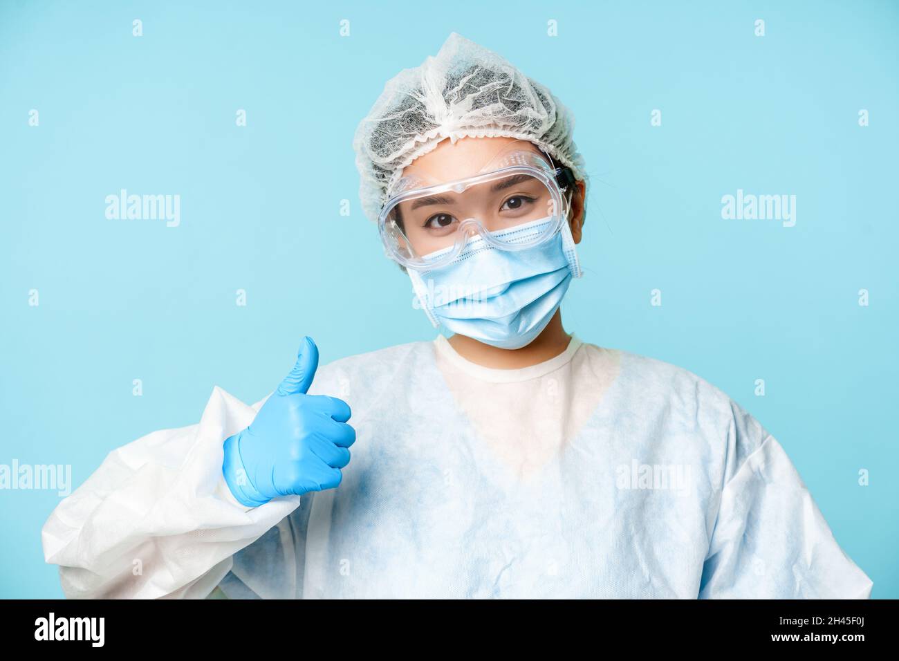 Smiling asian female nurse or doctor, wearing ppe, personal protective ...