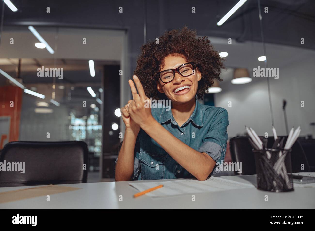 Pretty young woman speaking in sign language in the office Stock Photo ...
