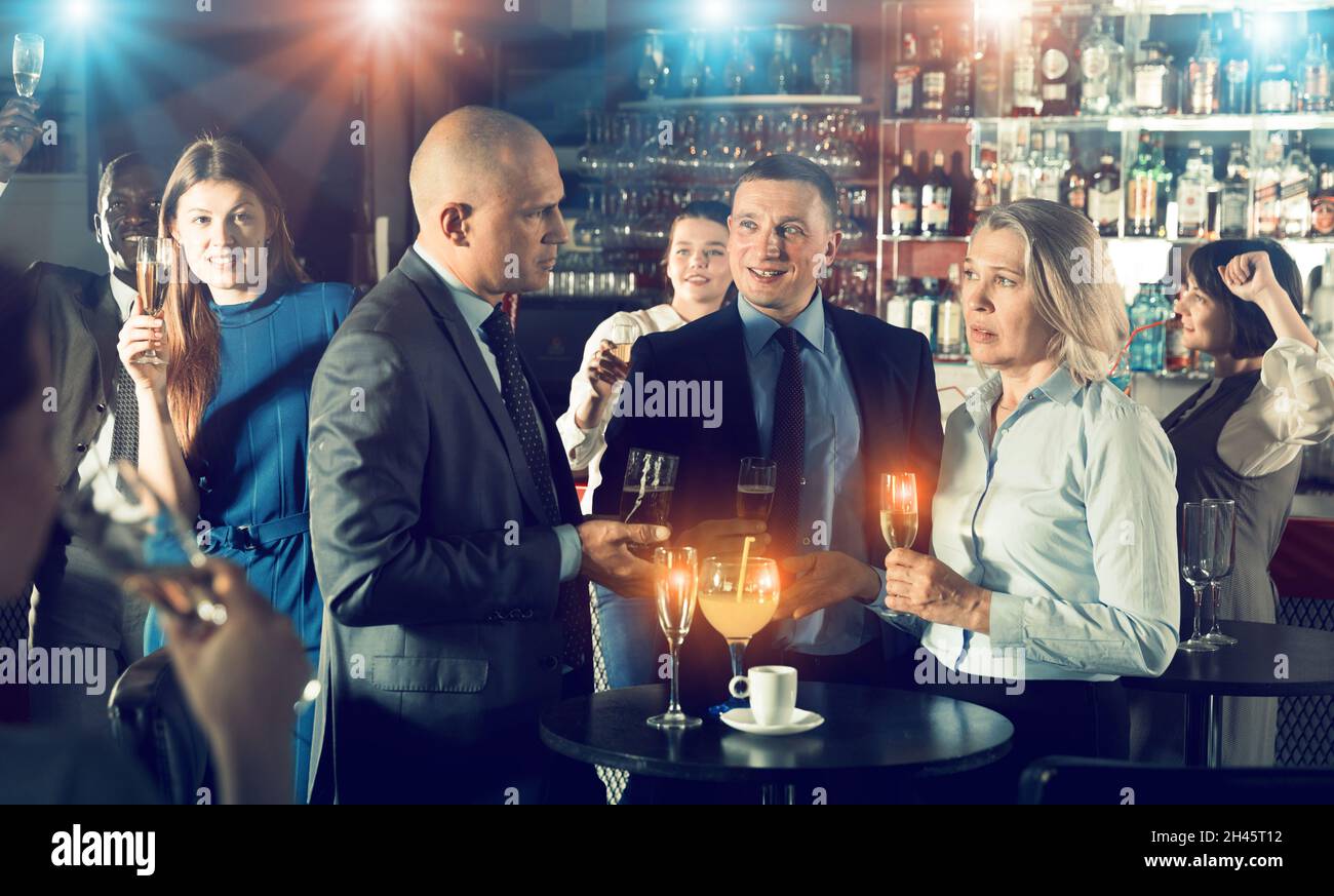 Three colleagues talking on party Stock Photo - Alamy