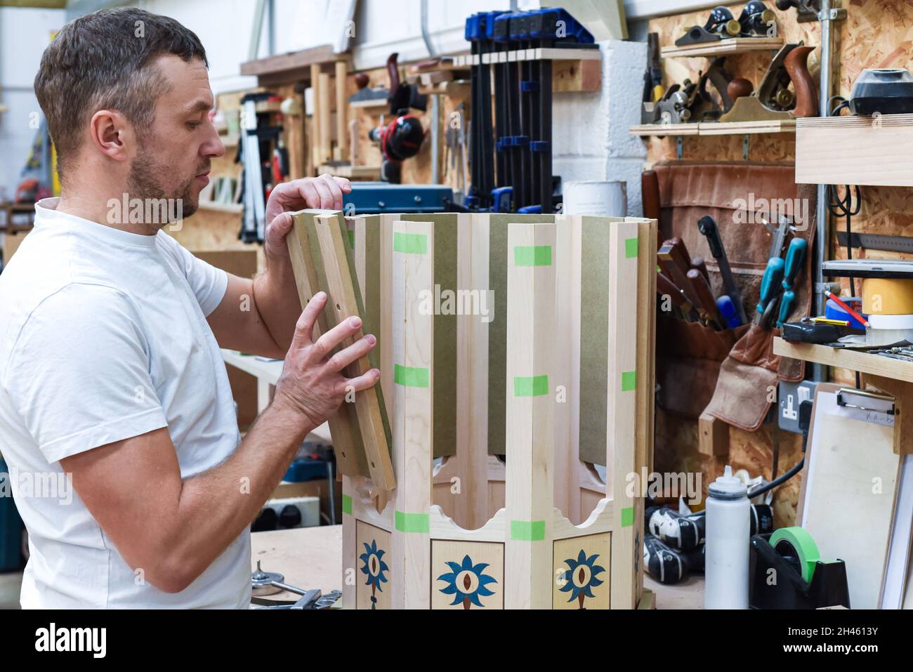 A man is making bespoke furniture in a woodwork workshop showing the ...