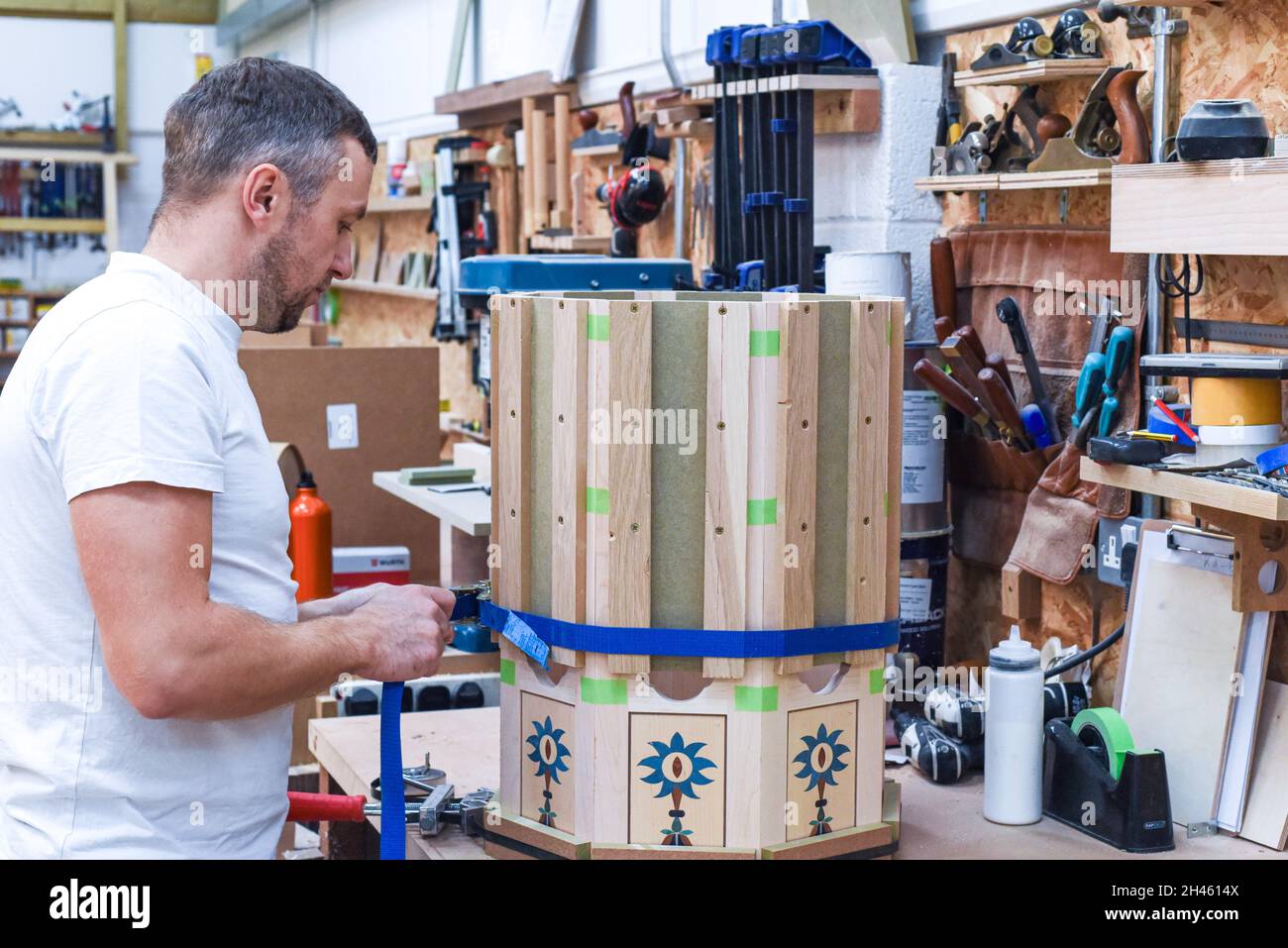 A man is making bespoke furniture in a woodwork workshop showing the ...