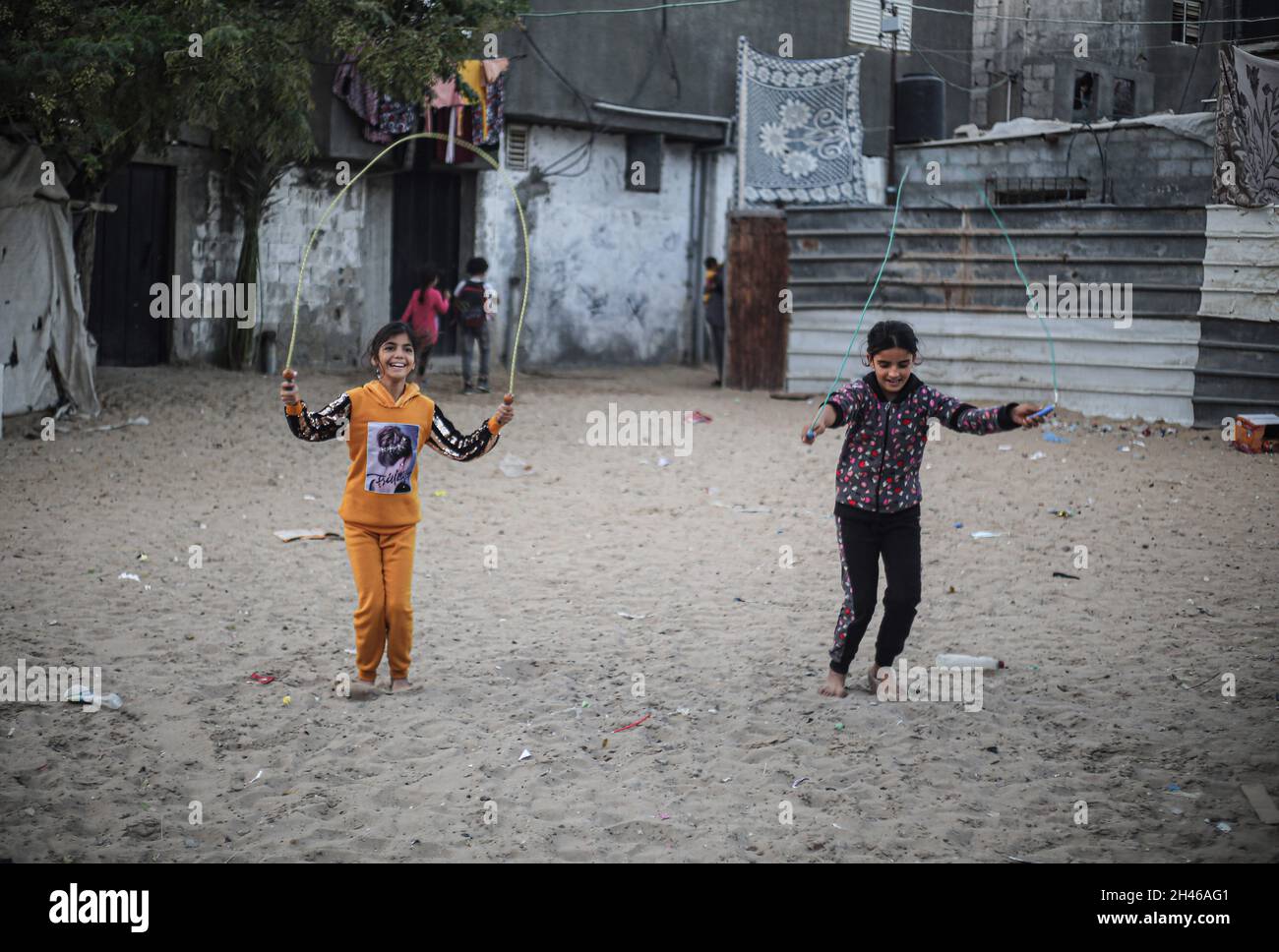 Palestinian children are seen skipping ropes in front of their house in ...