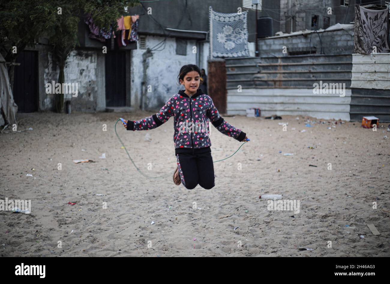 A Palestinian child seen skipping a rope in front of her house in a ...