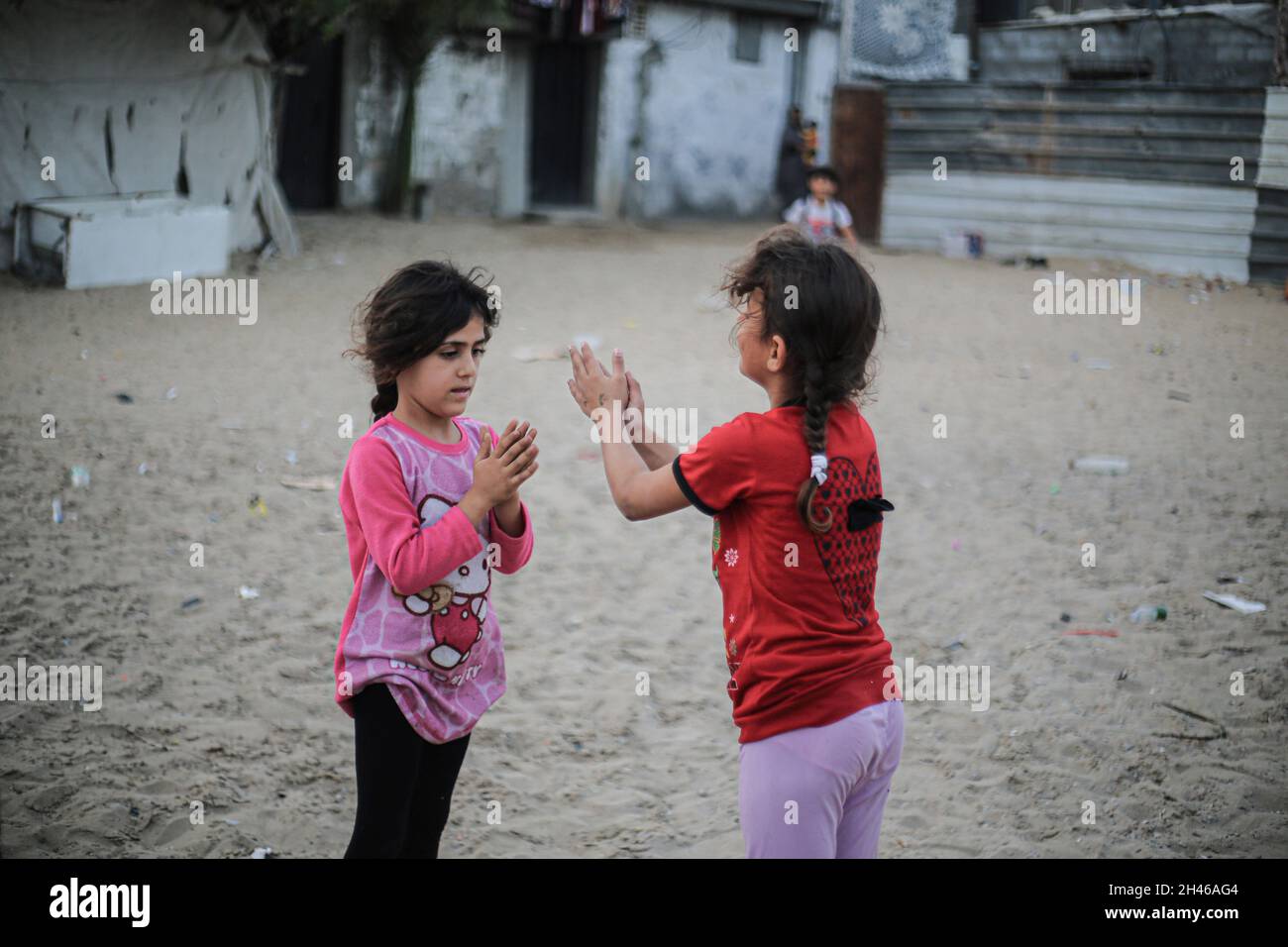 Palestinian children play in front of their house in a poor ...