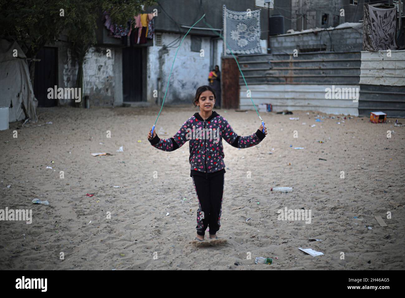 A Palestinian child seen skipping a rope in front of her house in a ...
