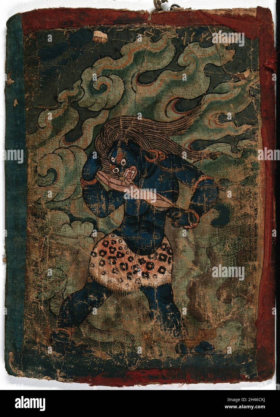 A blue Tibetan demon about to eat a human body stretched between his ...