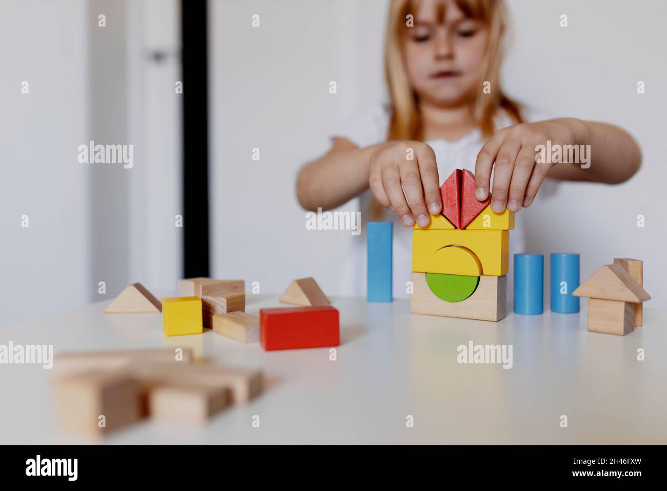 Child girl playing with colorful wooden toy building blocks. Little kid ...