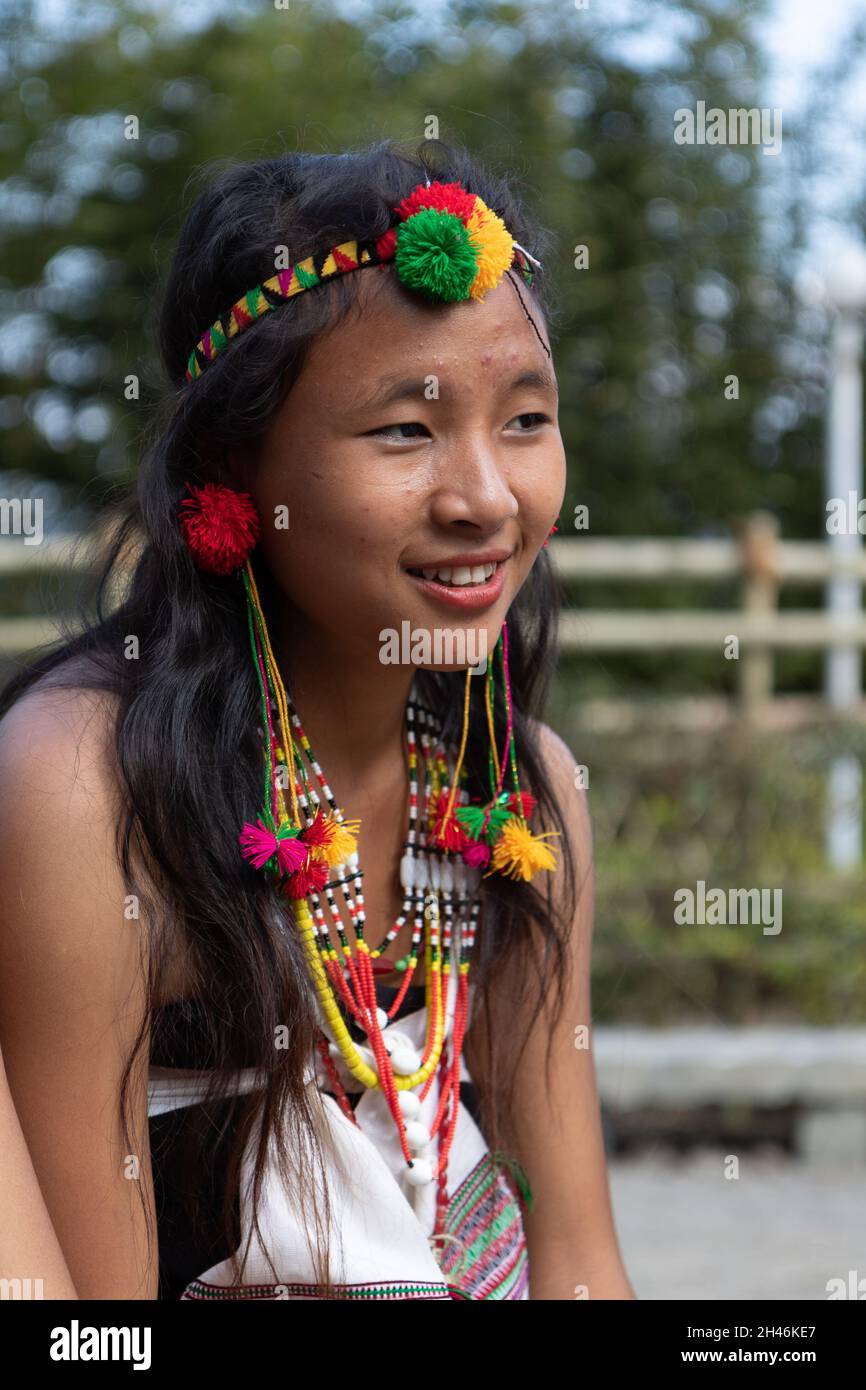 Portrait of a young tribal Naga girl siting and smiling dressed in ...