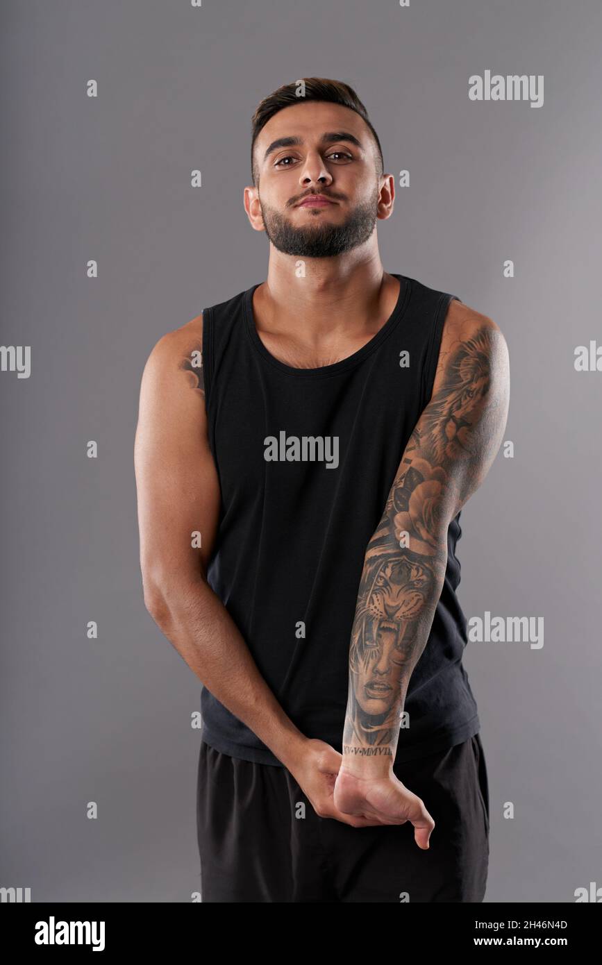 Portrait of handsome young man enjoying stretching arms after working ...