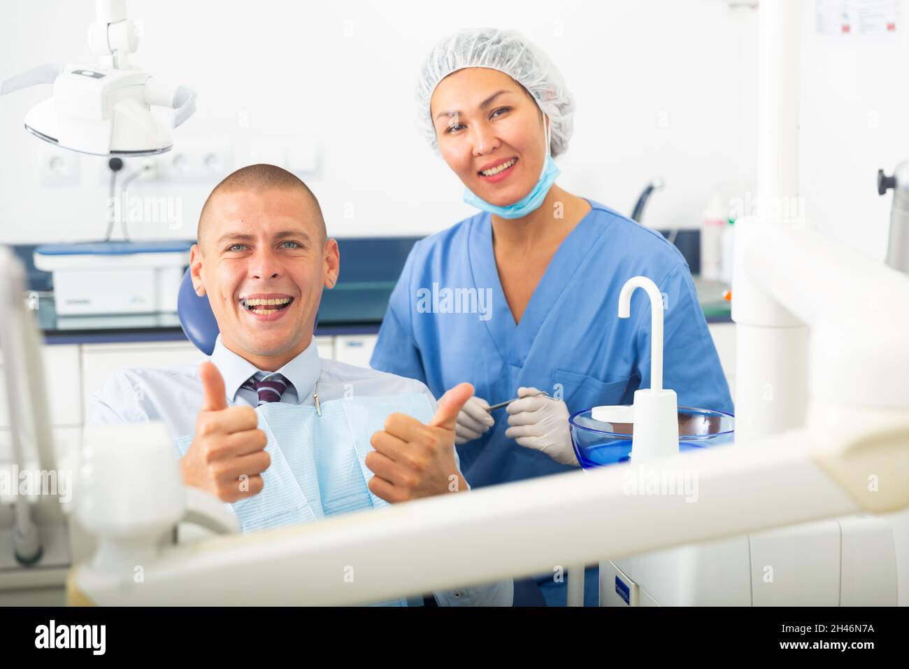 Satisfied patient visiting dentist giving thumbs up Stock Photo - Alamy