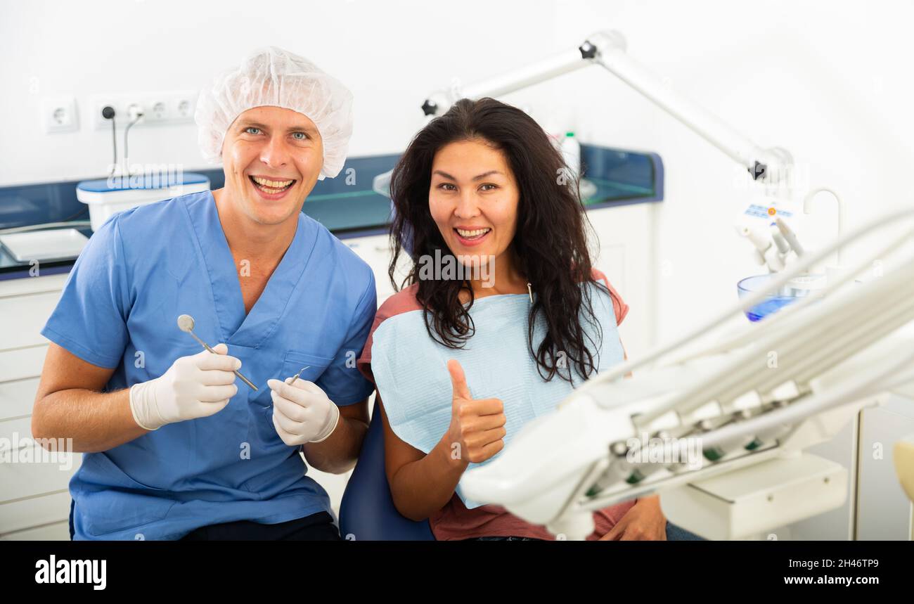 Satisfied patient visiting dentist giving thumbs up Stock Photo - Alamy
