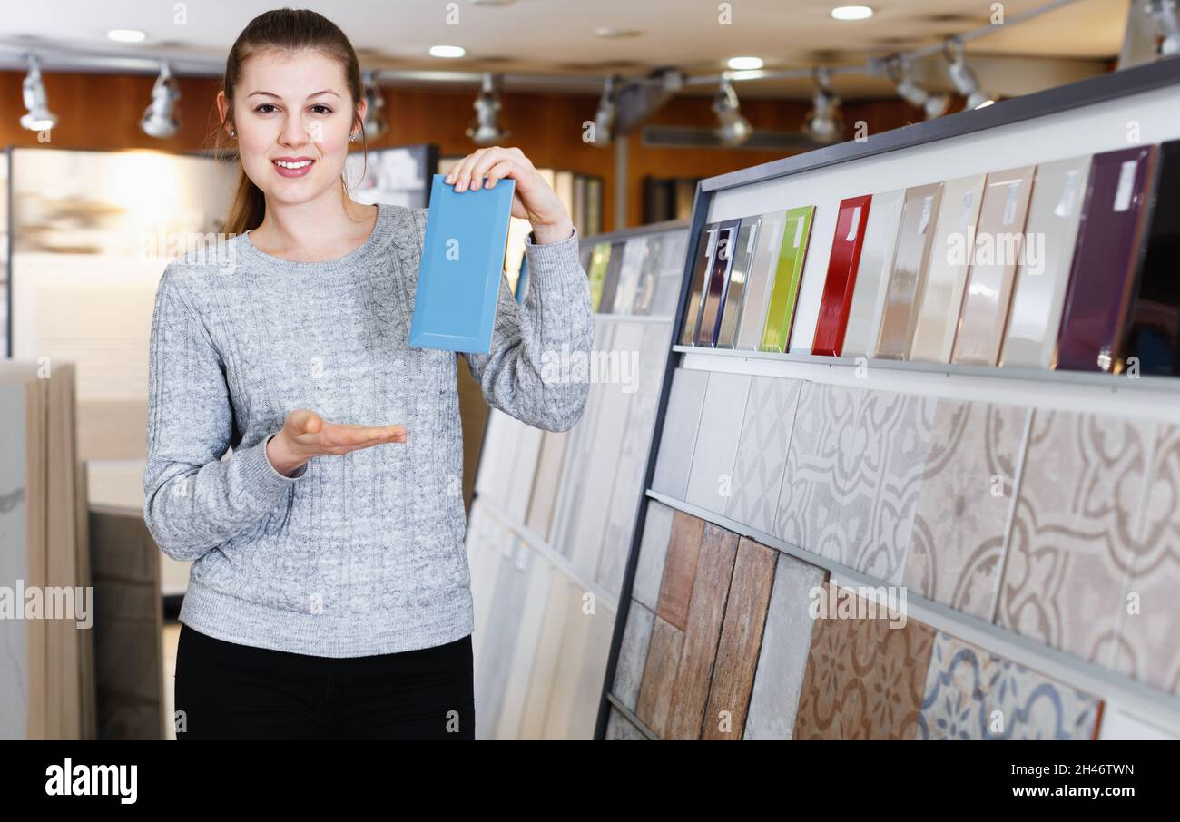 Portrait of female looking sample of ceramic tile in shop Stock Photo ...