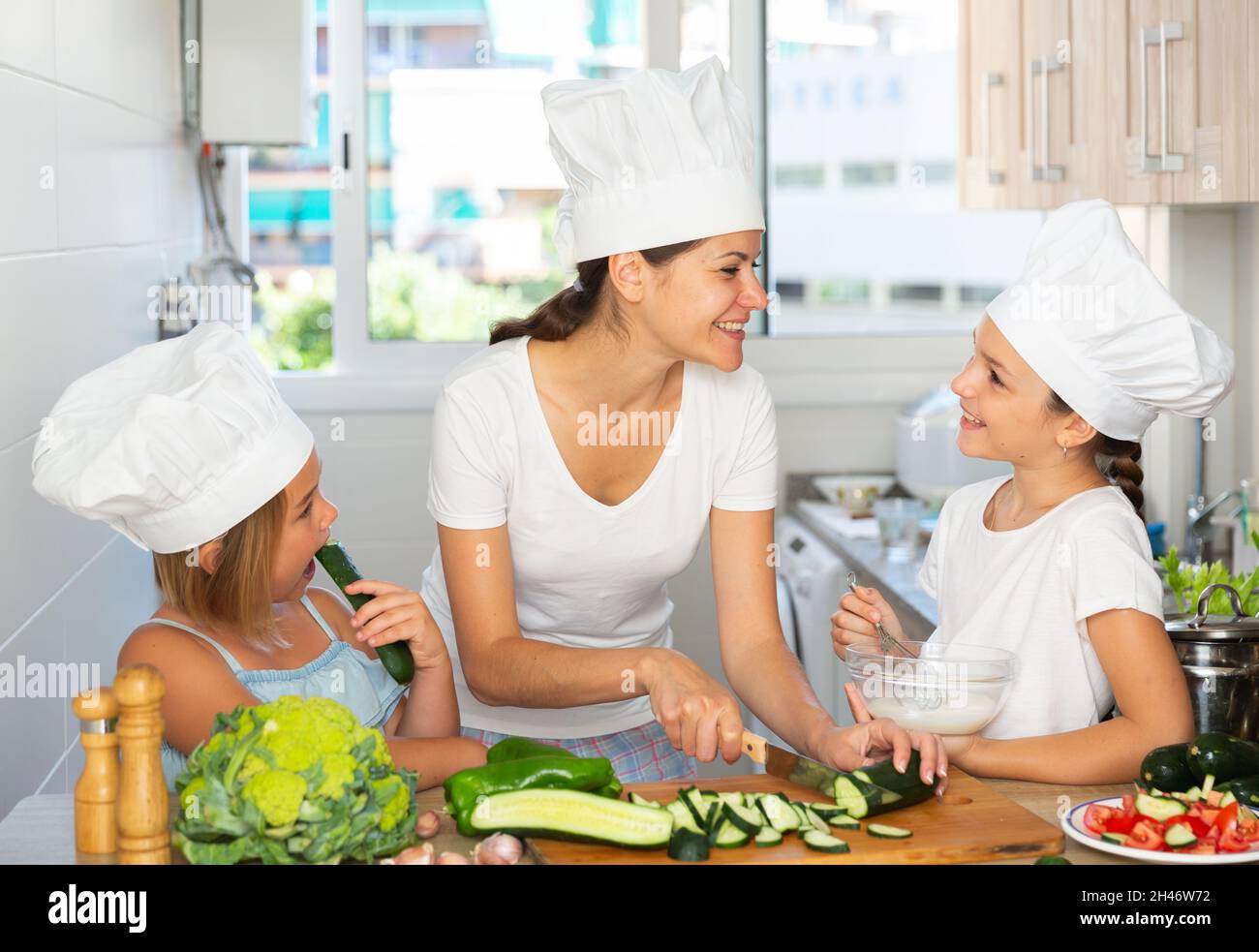 Young woman and two girls cooking together Stock Photo - Alamy