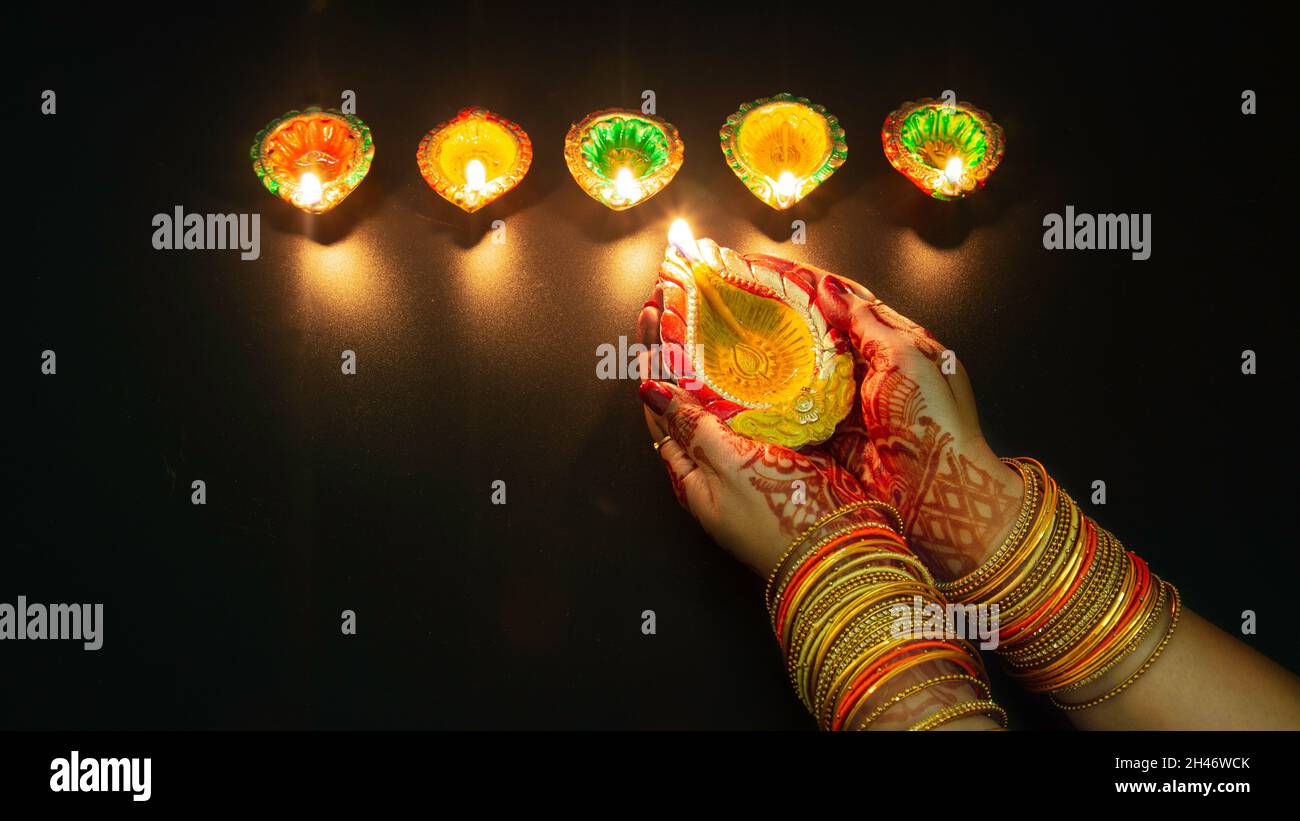 Traditional indian woman lighting diya hi-res stock photography and ...