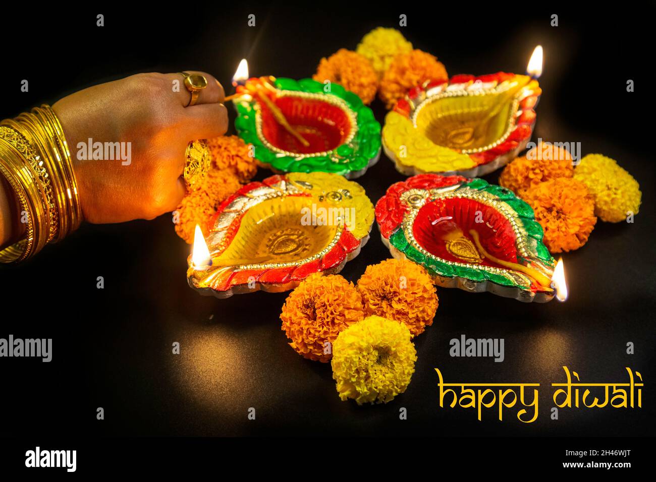 Traditional indian woman lighting diya hi-res stock photography and ...