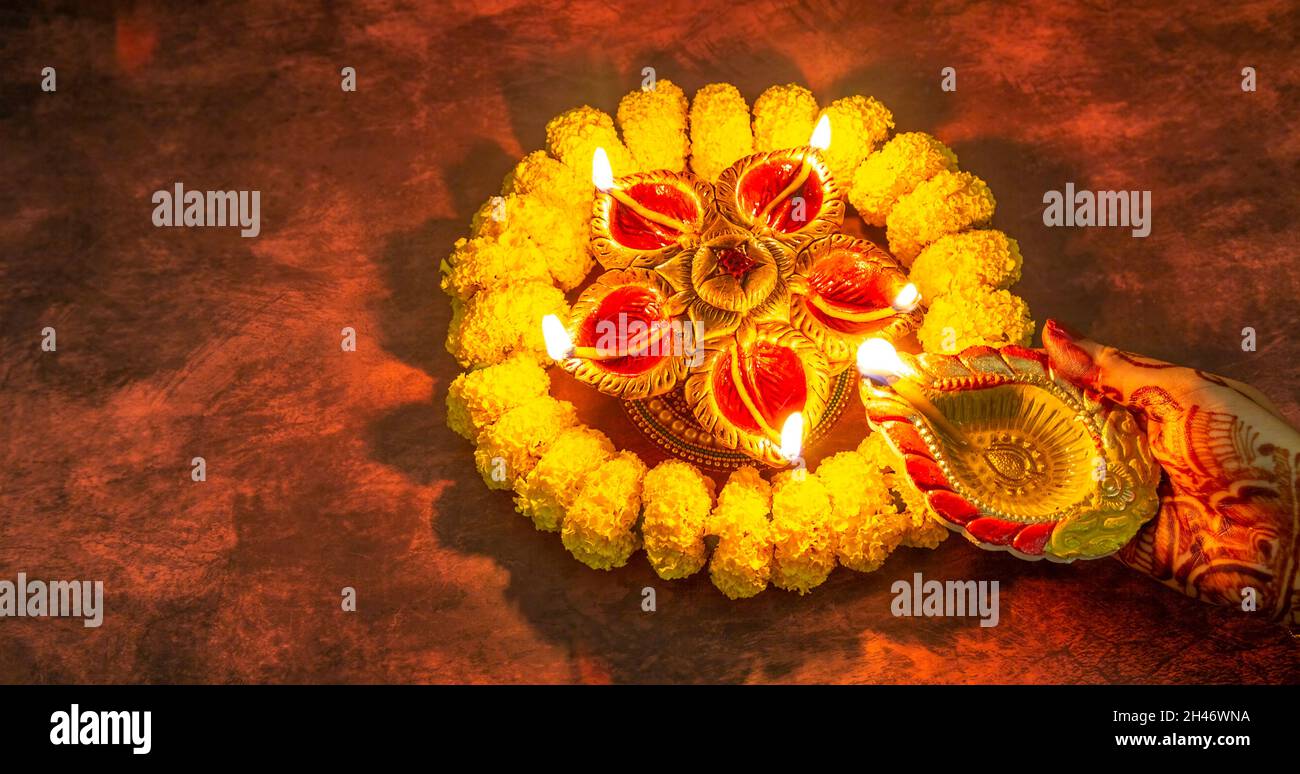 Traditional indian woman lighting diya hi-res stock photography and ...