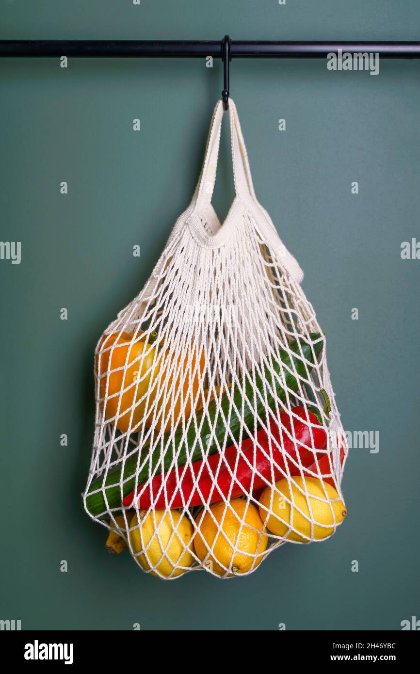 A reusable shopping string bag with vegetables and fruit from the ...