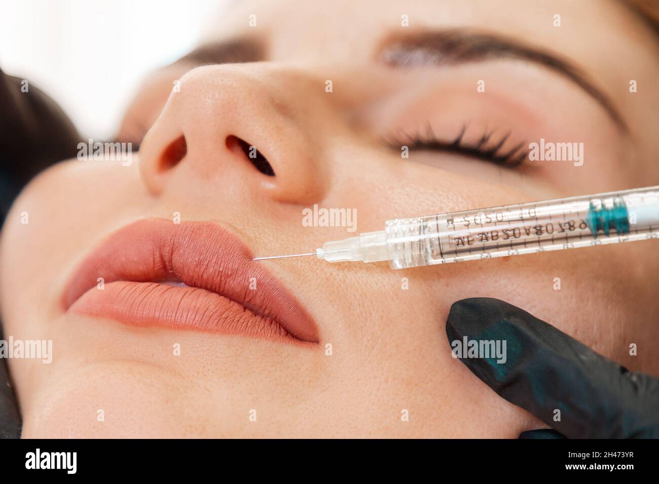 Aesthetic medicine and cosmetology. Cosmetologist in black latex gloves ...