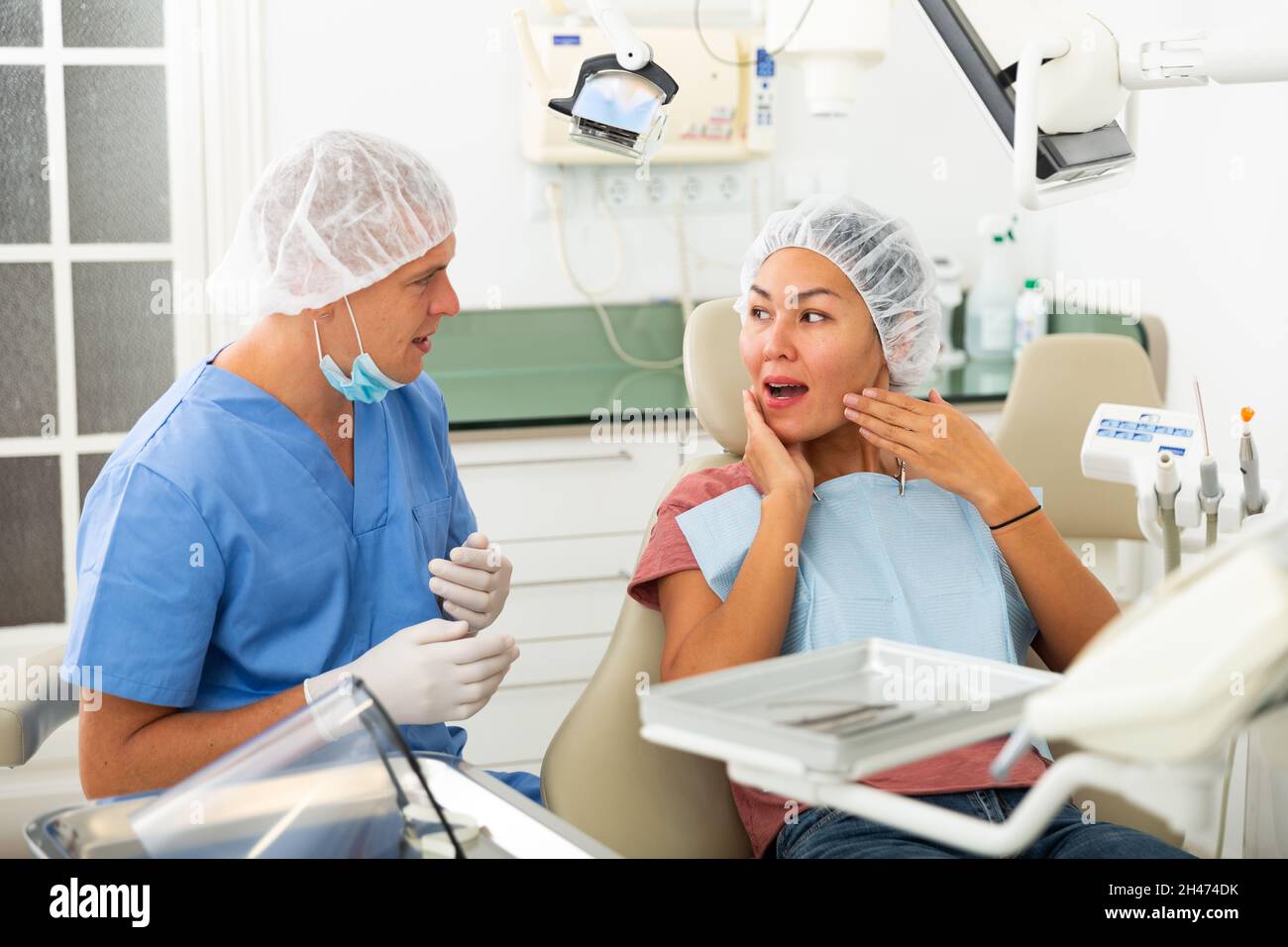 Female patient shows sick tooth to a dentist in dental clinic Stock ...