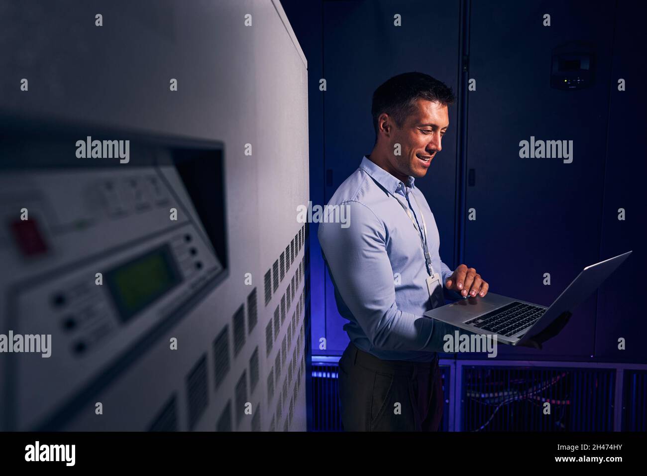 Cheerful male employee working in data center Stock Photo - Alamy