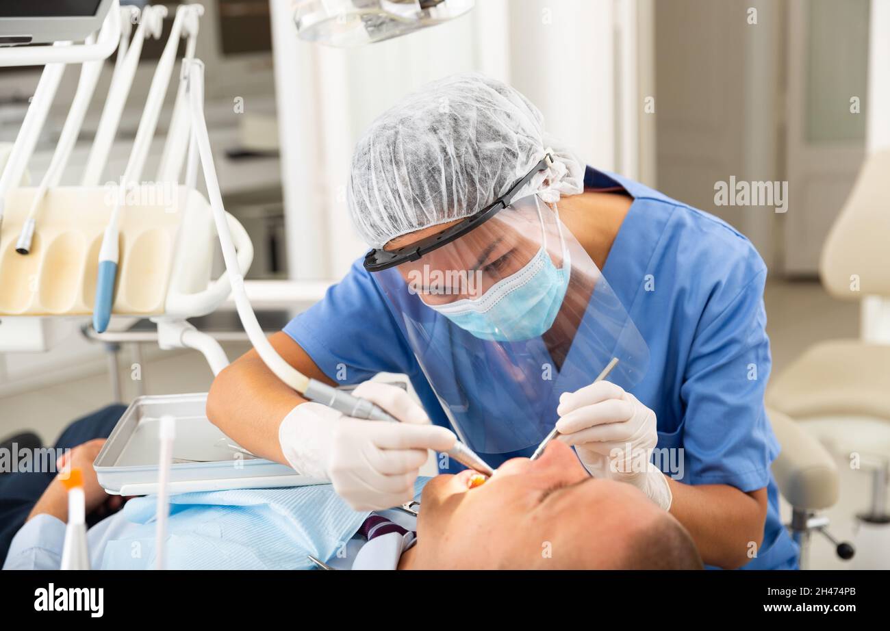 Doctor treats patient teeth in hi-res stock photography and images - Alamy