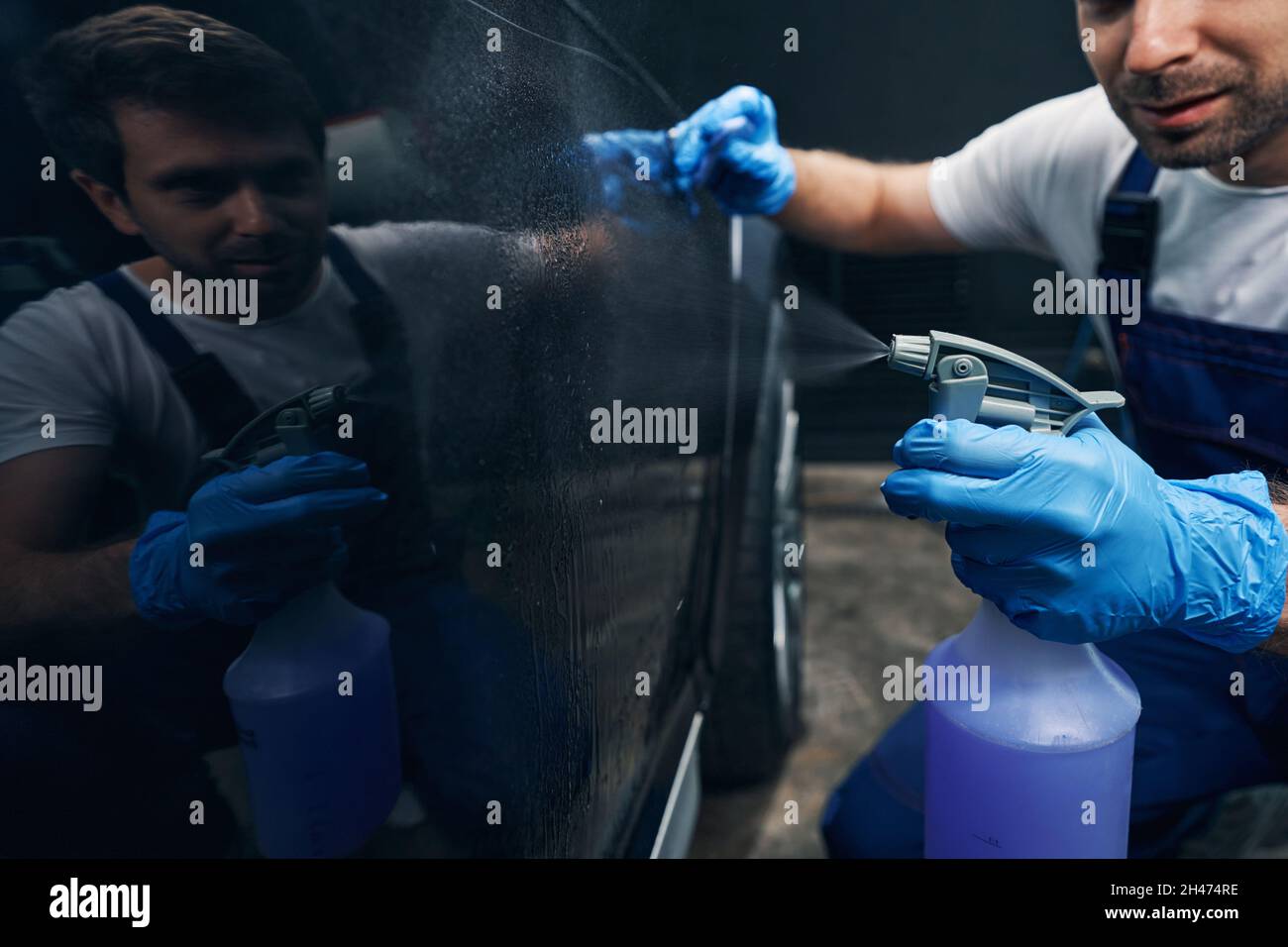 Degreasing liquid flying out of spray bottle on car Stock Photo - Alamy