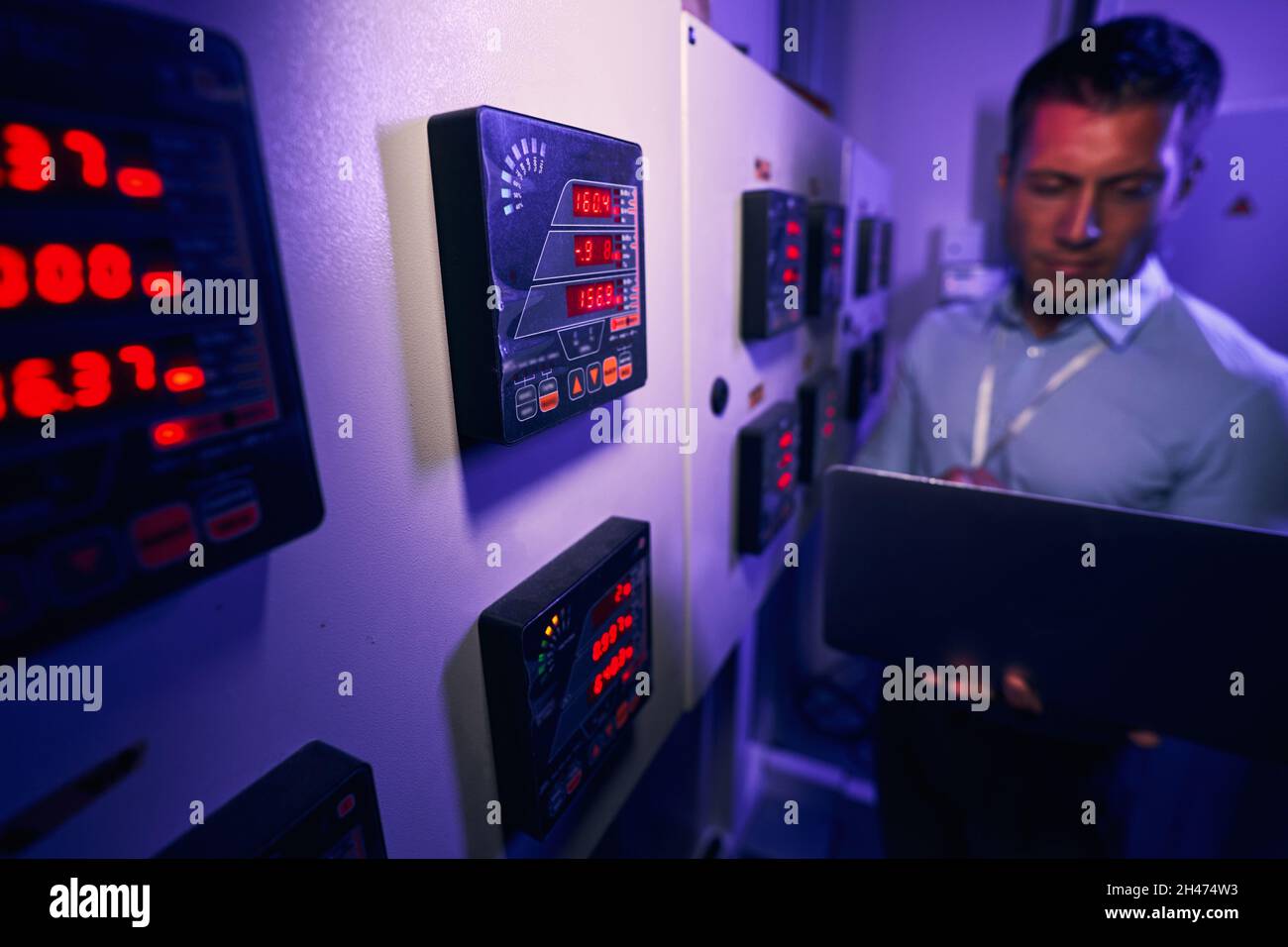 Data center technician monitoring electric power equipment Stock Photo ...