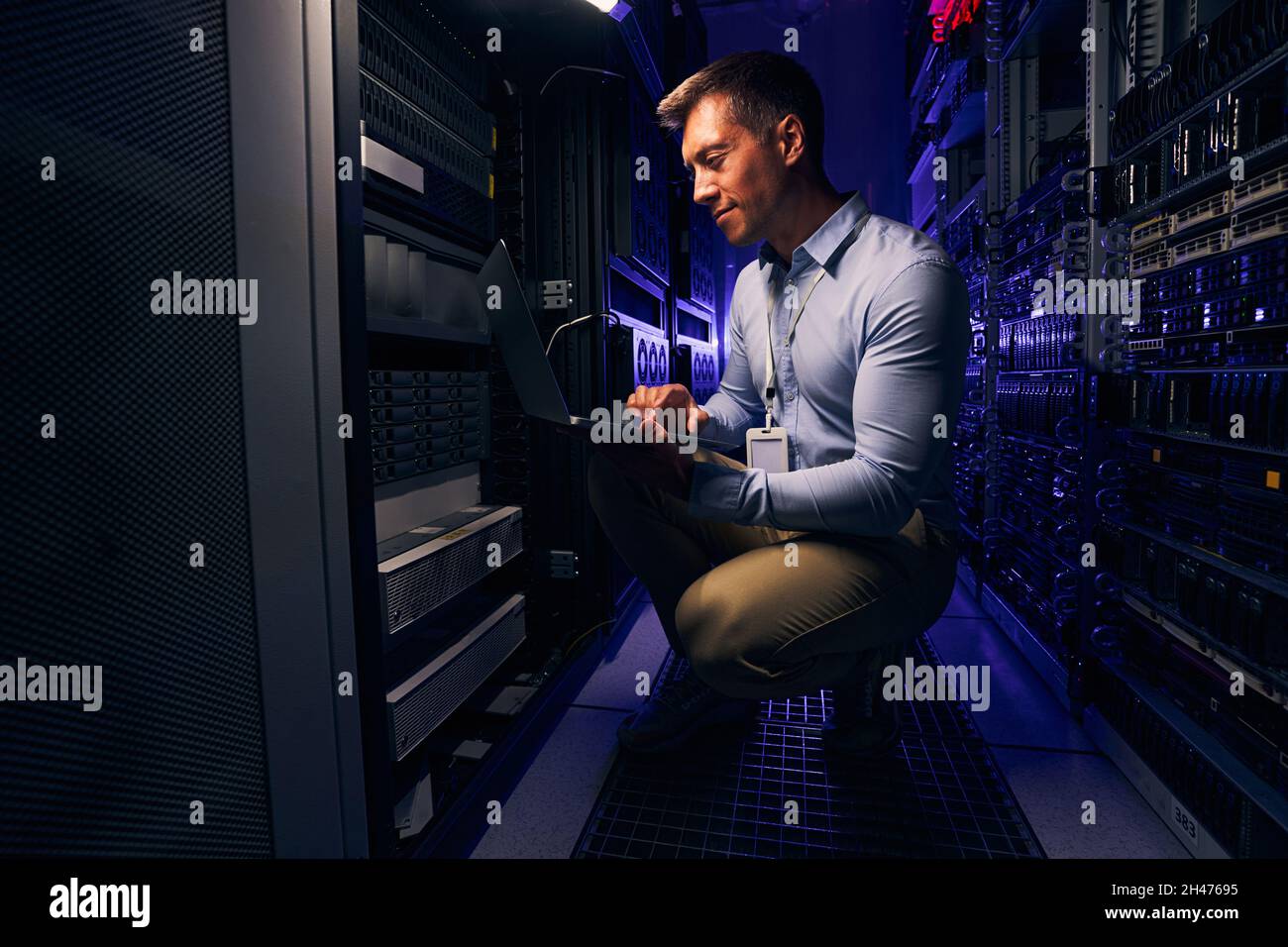 Employee checking hardware equipment in server room Stock Photo - Alamy