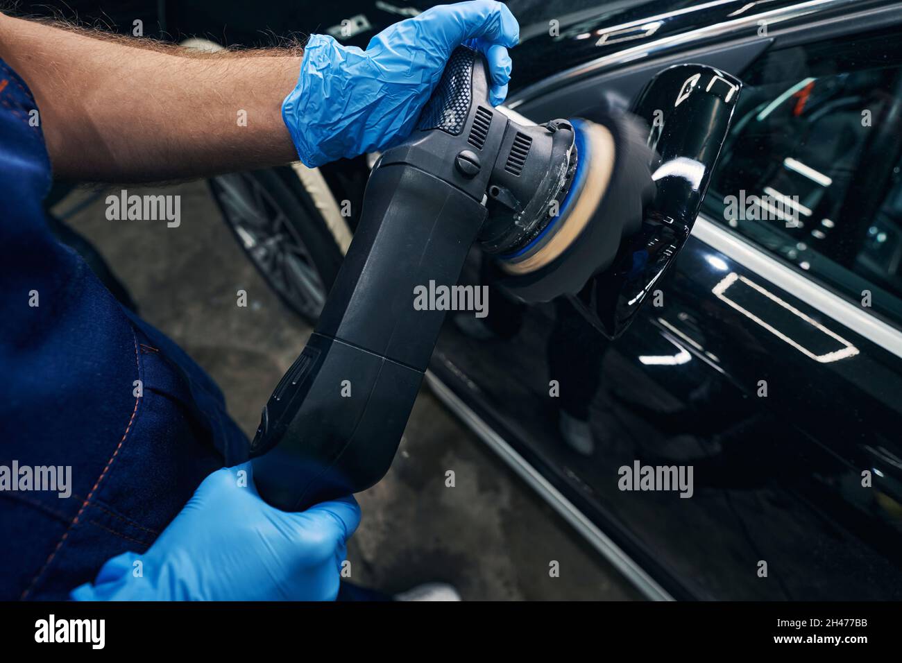 Polisher in hands of mechanic grinding car driving mirror Stock Photo ...