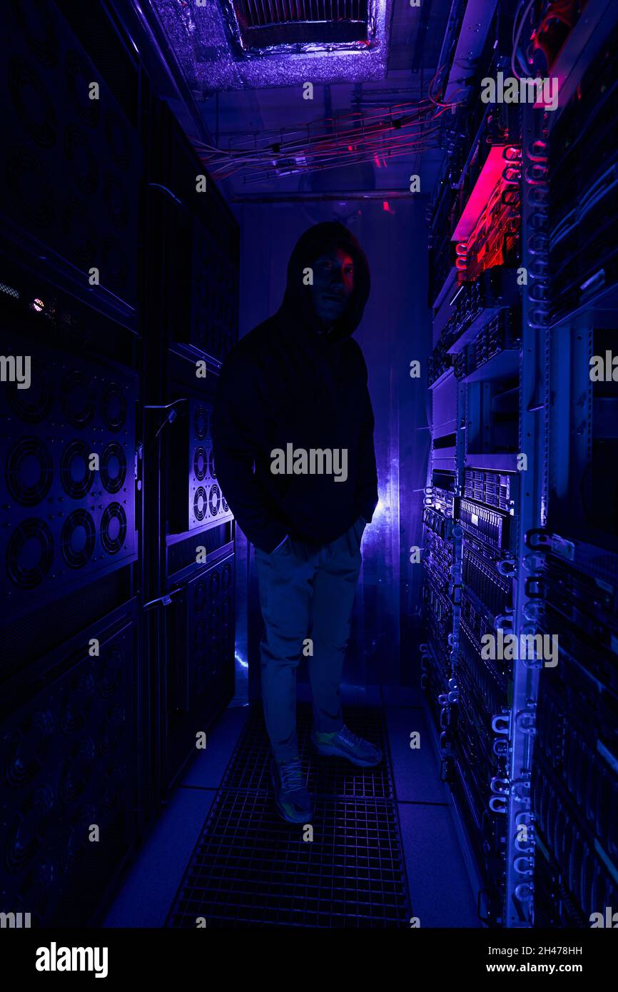 Tranquil Caucasian male hacker in dark server room Stock Photo - Alamy
