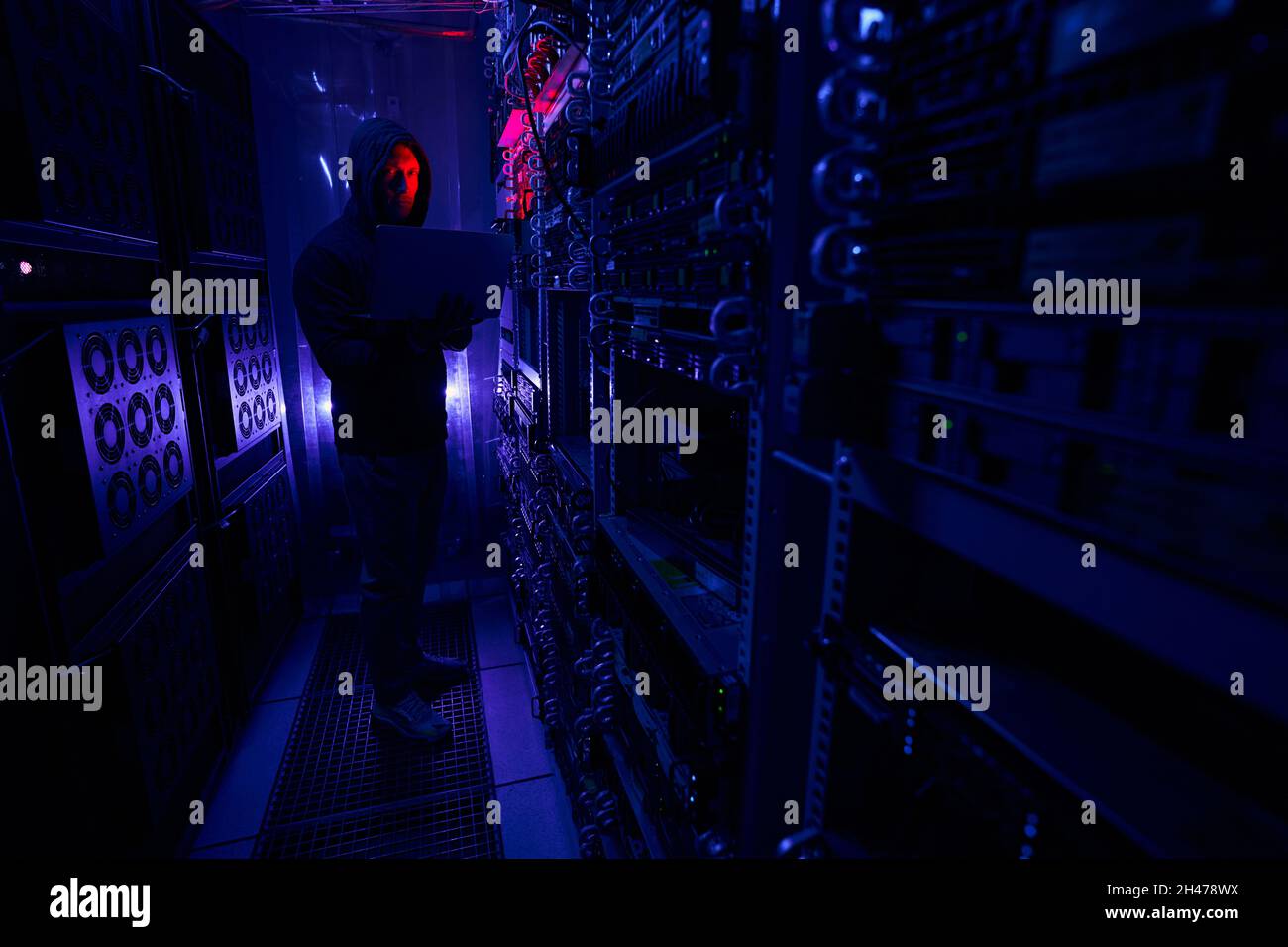 Hacker with laptop in his hands in dark server room Stock Photo - Alamy