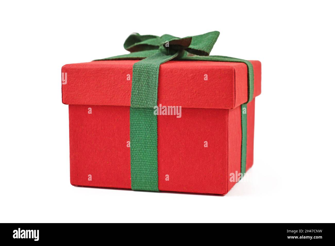 Side view of red Christmas gift box with green ribbon on white ...