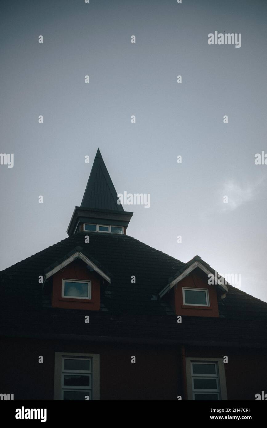 Vertical shot of a building with a tower and a sharp roof Stock Photo ...