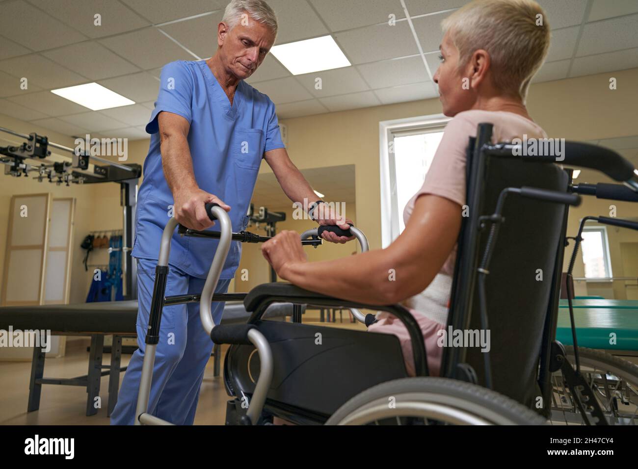 Patient woman uses with walking frame in rehab center Stock Photo - Alamy