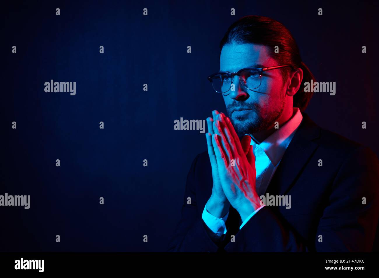 handsome man gestures with his hands with glasses dark background Stock ...