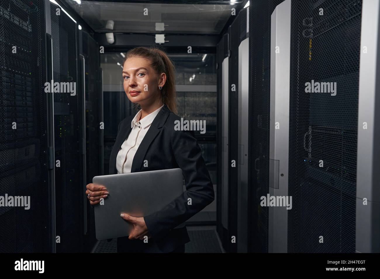 Confident businesswoman with laptop computer in data center Stock Photo ...