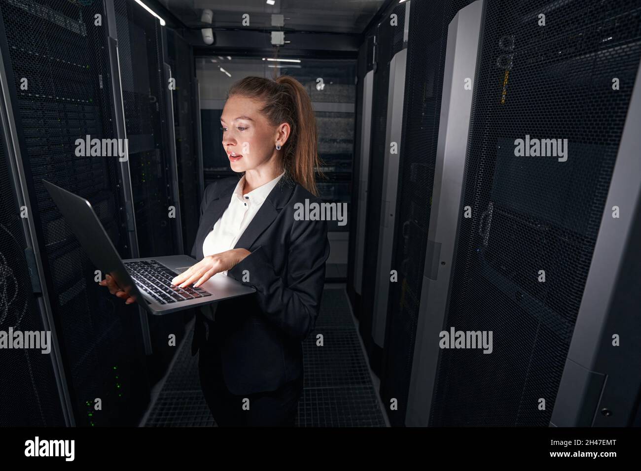 Female IT network manager working in server room Stock Photo - Alamy